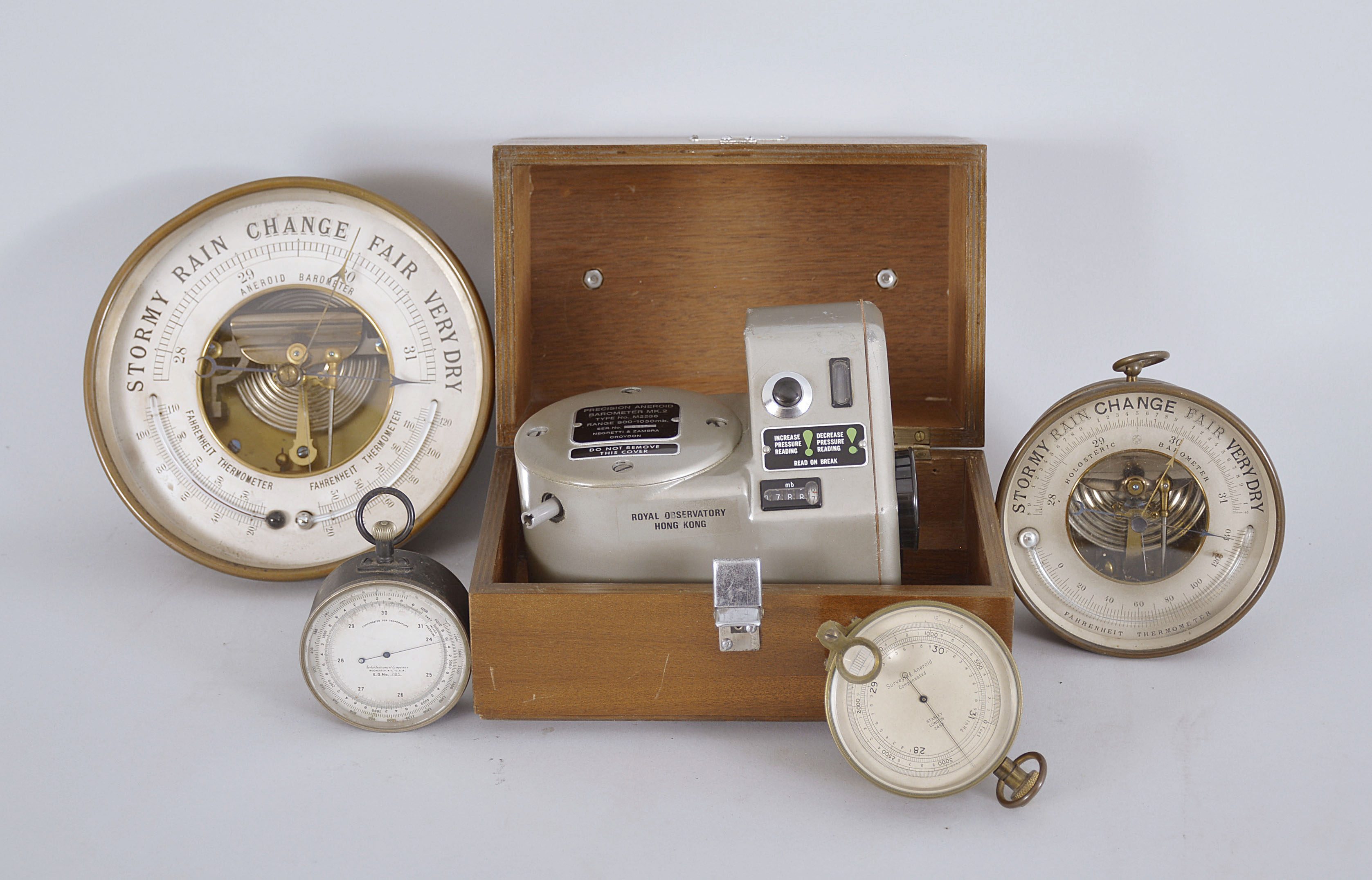 Assortement of five barometers including wall, pocket, and boxed precision